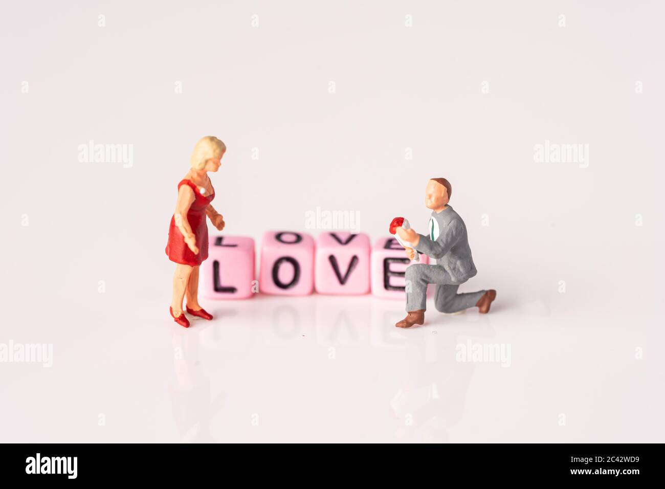 Love concept. Miniature couple against pink background Stock Photo - Alamy