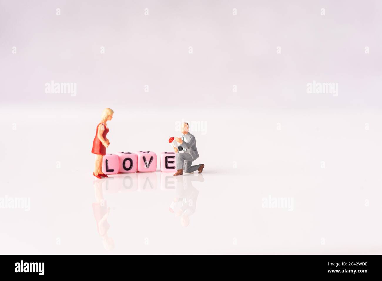 Love concept. Miniature couple against pink background Stock Photo - Alamy