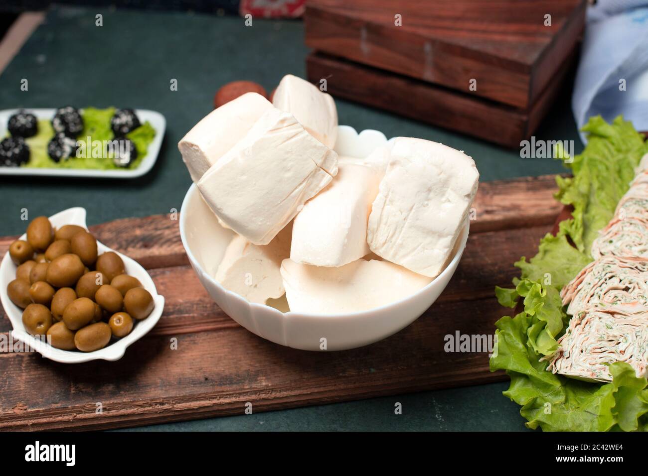 Sliced white cheese in a bowl with green olives Stock Photo - Alamy