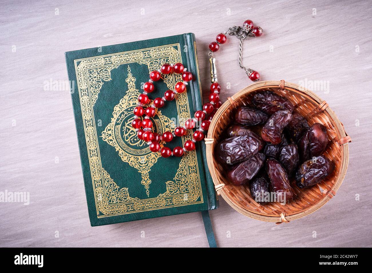 Flat lay composition of Qoran and Tasbih (rosary beads). The words on ...