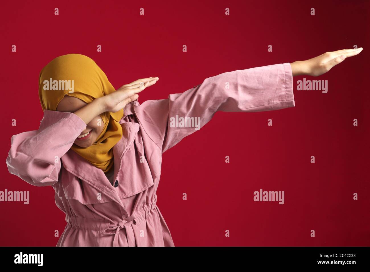 Portrait of funny young Asian muslim, teenage girl smiling and making ...
