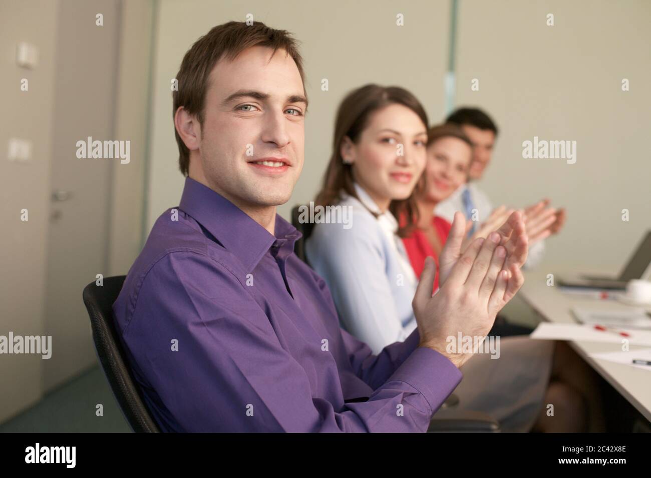 Four business people are clapping around a conference table - applause ...