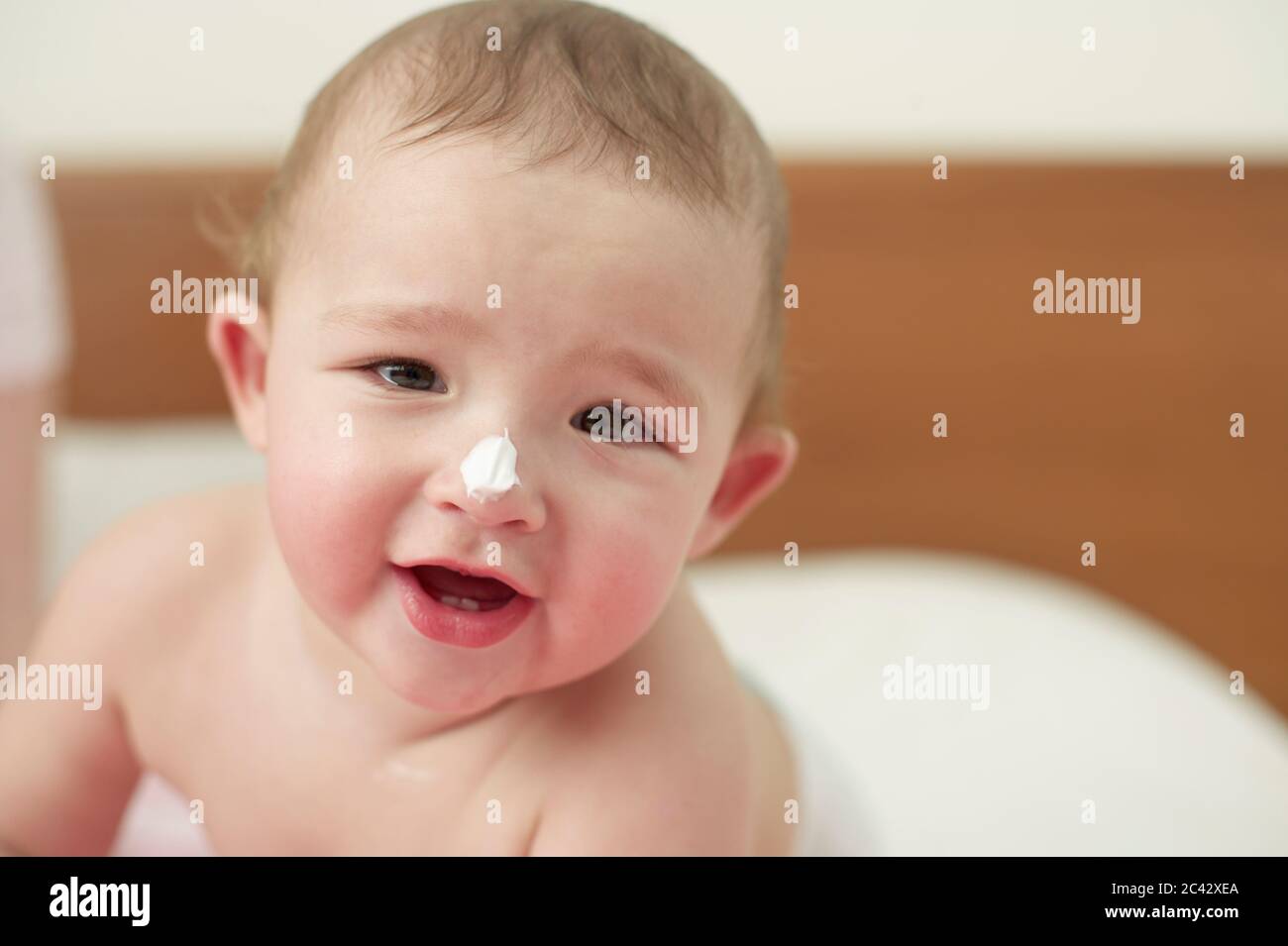 Baby with cream on her nose Stock Photo - Alamy