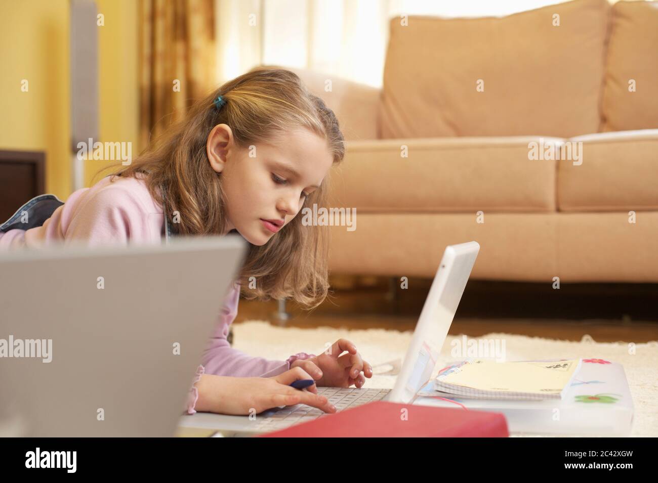 Little girl is doing her chores with a laptop - technology age Stock ...