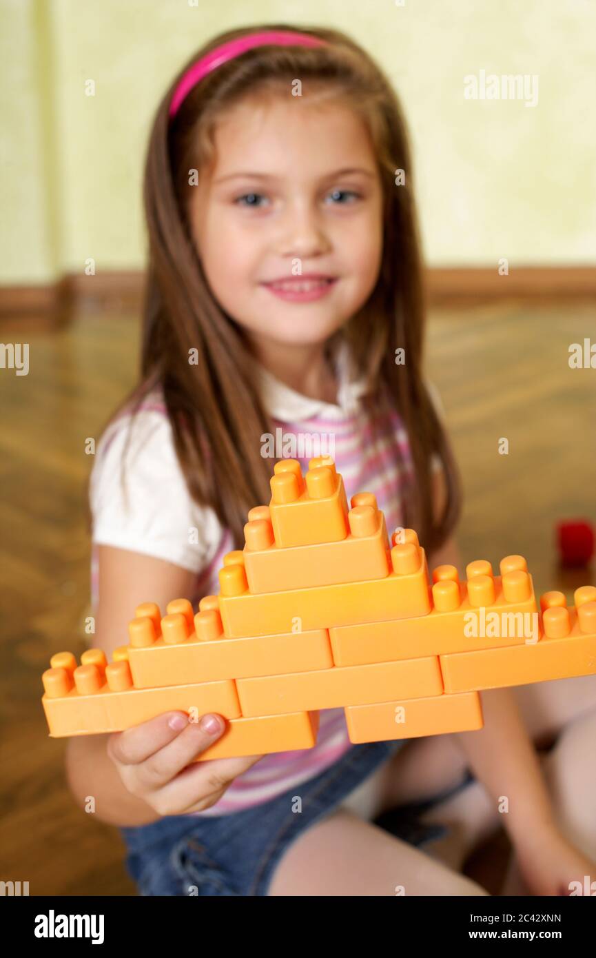Girl holds a structure made of Lego bricks in her hand - playing ...