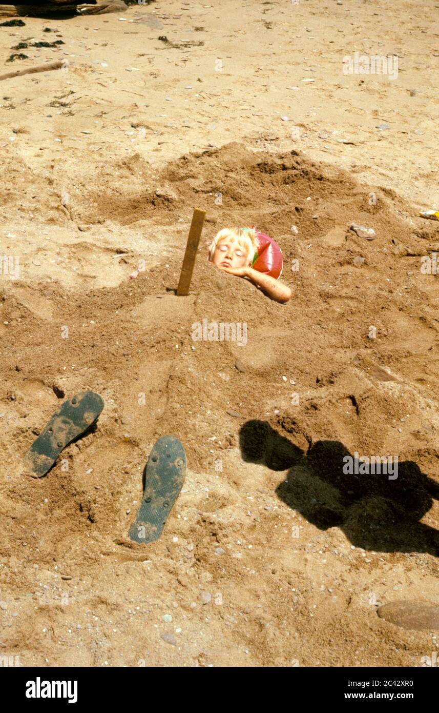 Children child buried sand hi-res stock photography and images - Alamy