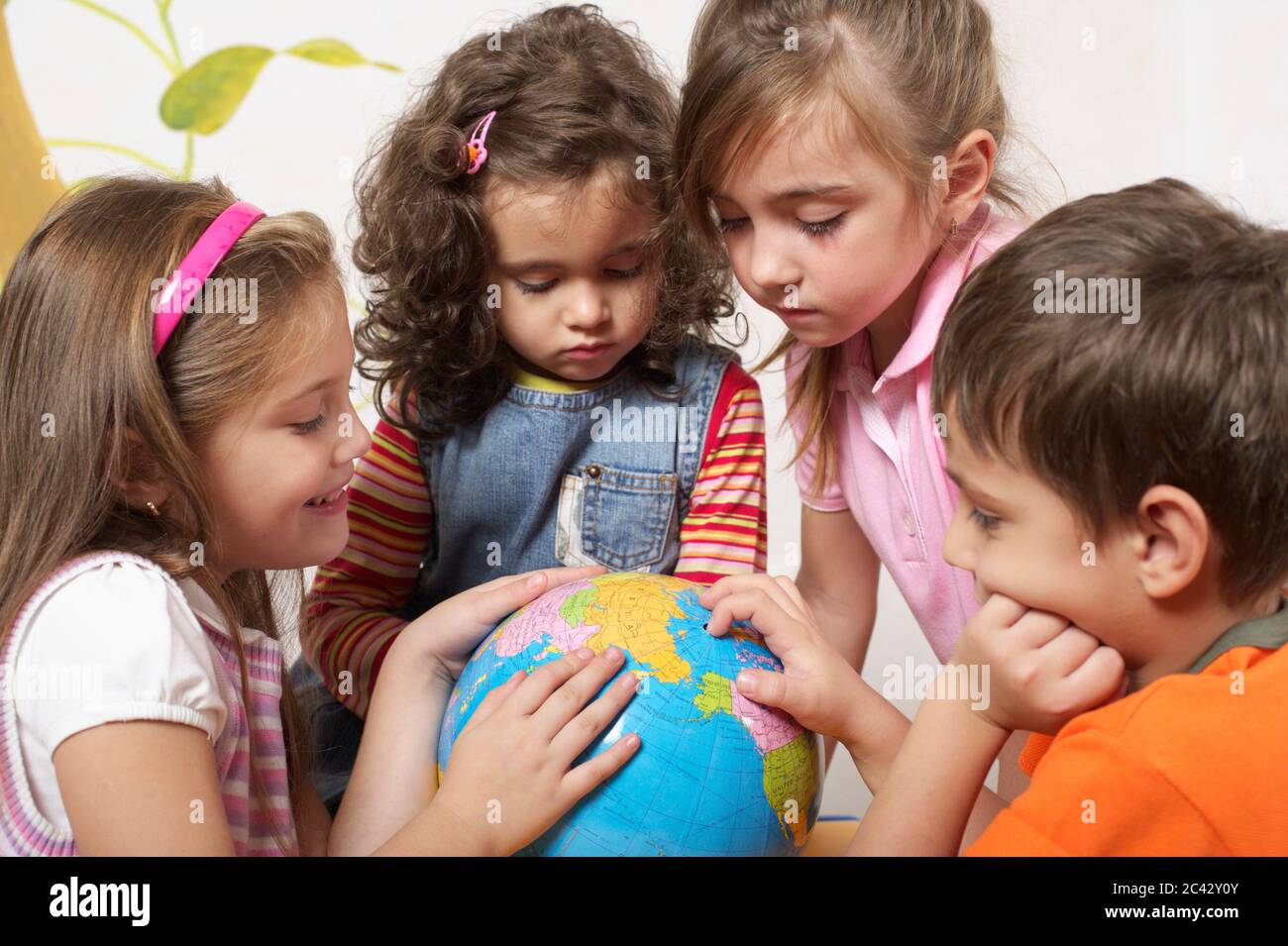 Four children touch a globe - nationality - learning - preschool Stock ...