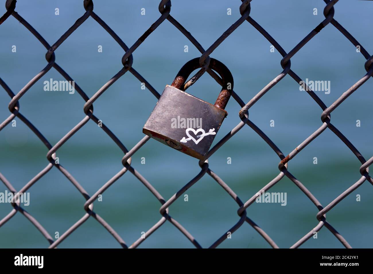 Metal Padlock with Heart and Bow and Arrow Symbol Attached to a Barbed ...