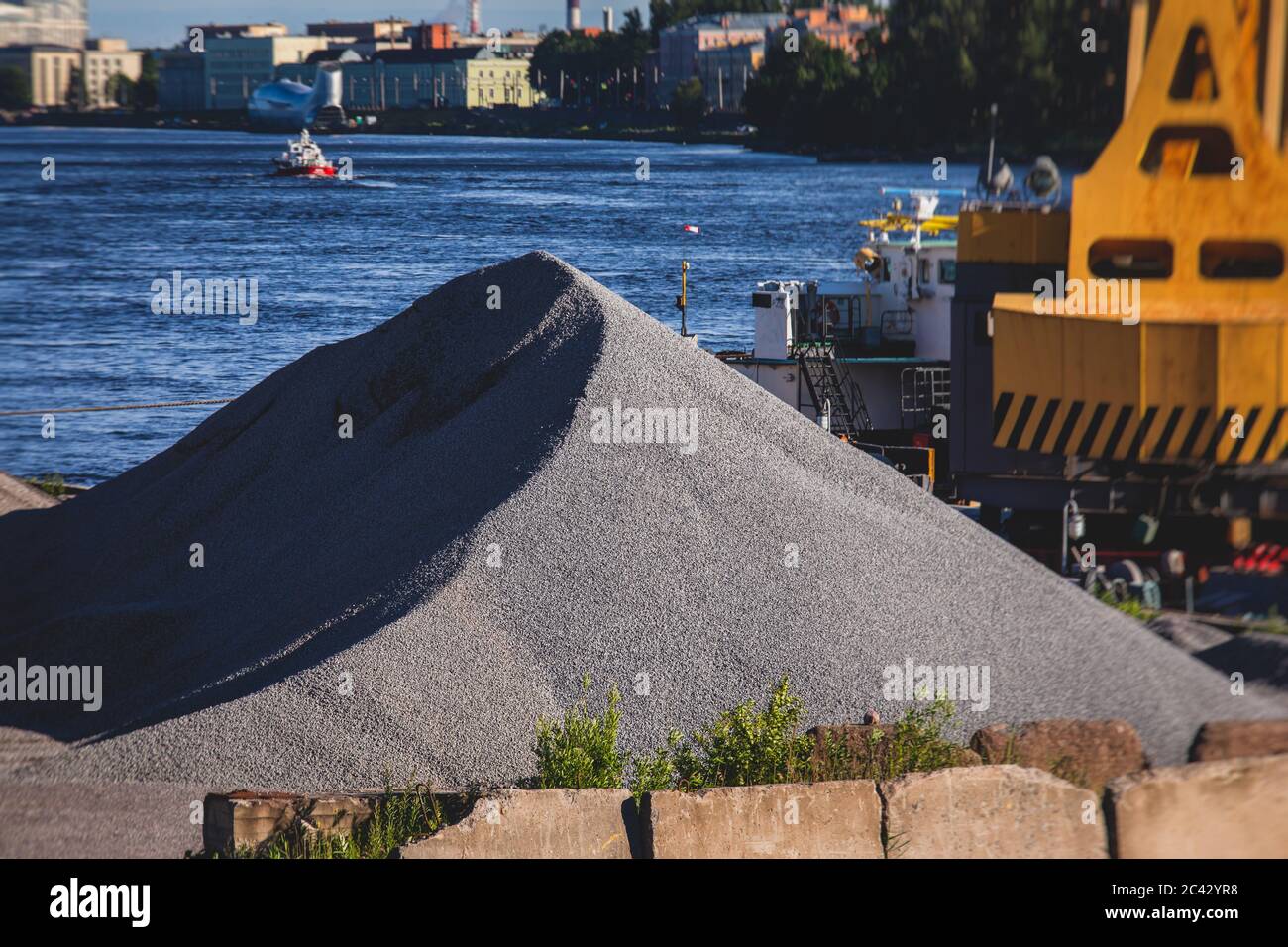 Bulk-handling crane unloading sand, road metal and gravel from cargo ...
