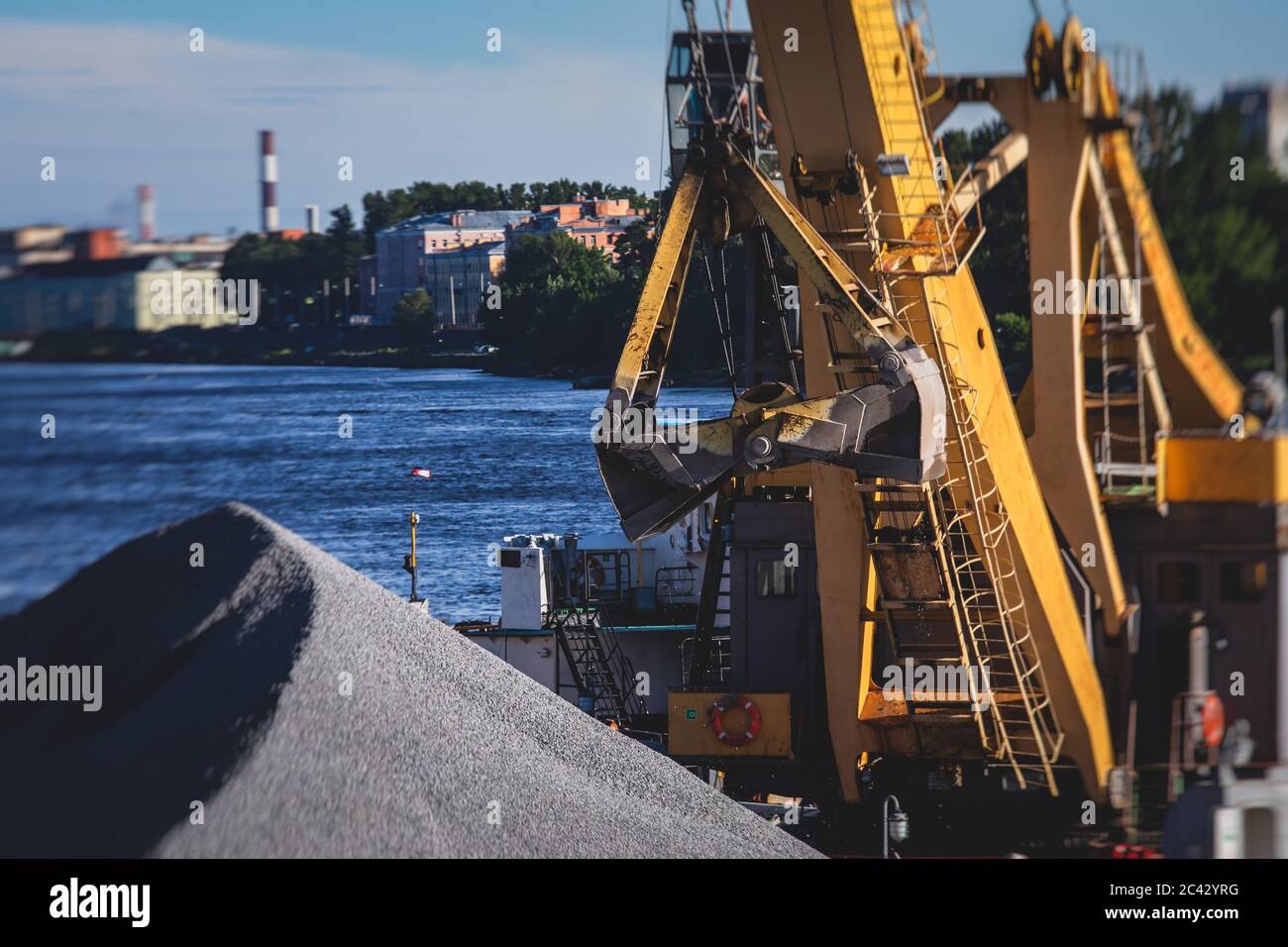Bulk-handling crane unloading sand, road metal and gravel from cargo ...
