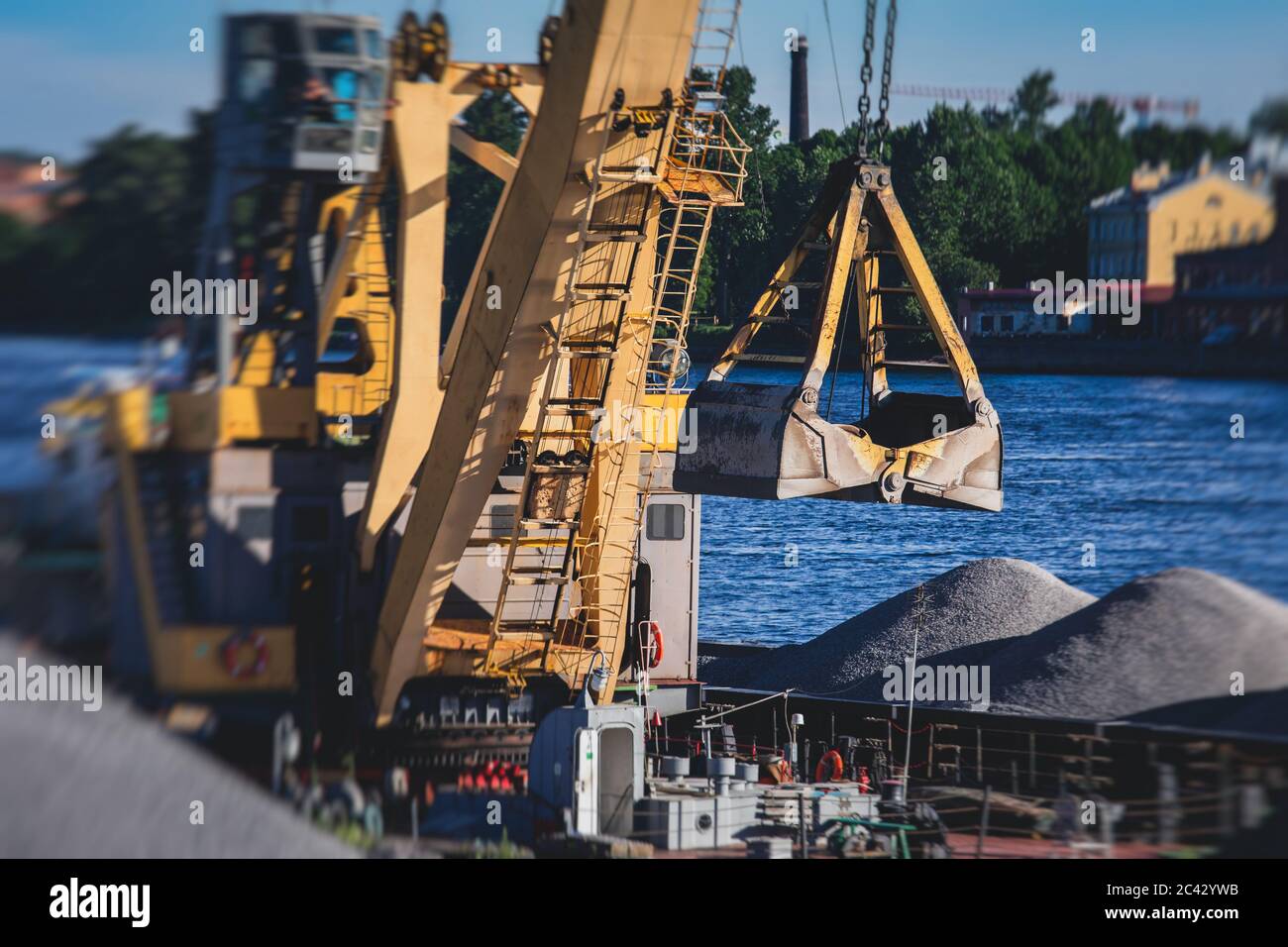 Bulk-handling crane unloading sand, road metal and gravel from cargo ...