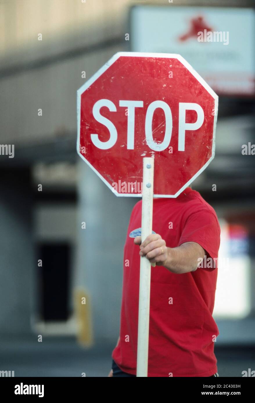 Man with red shirt holds stop sign in his hand - traffic Stock Photo ...