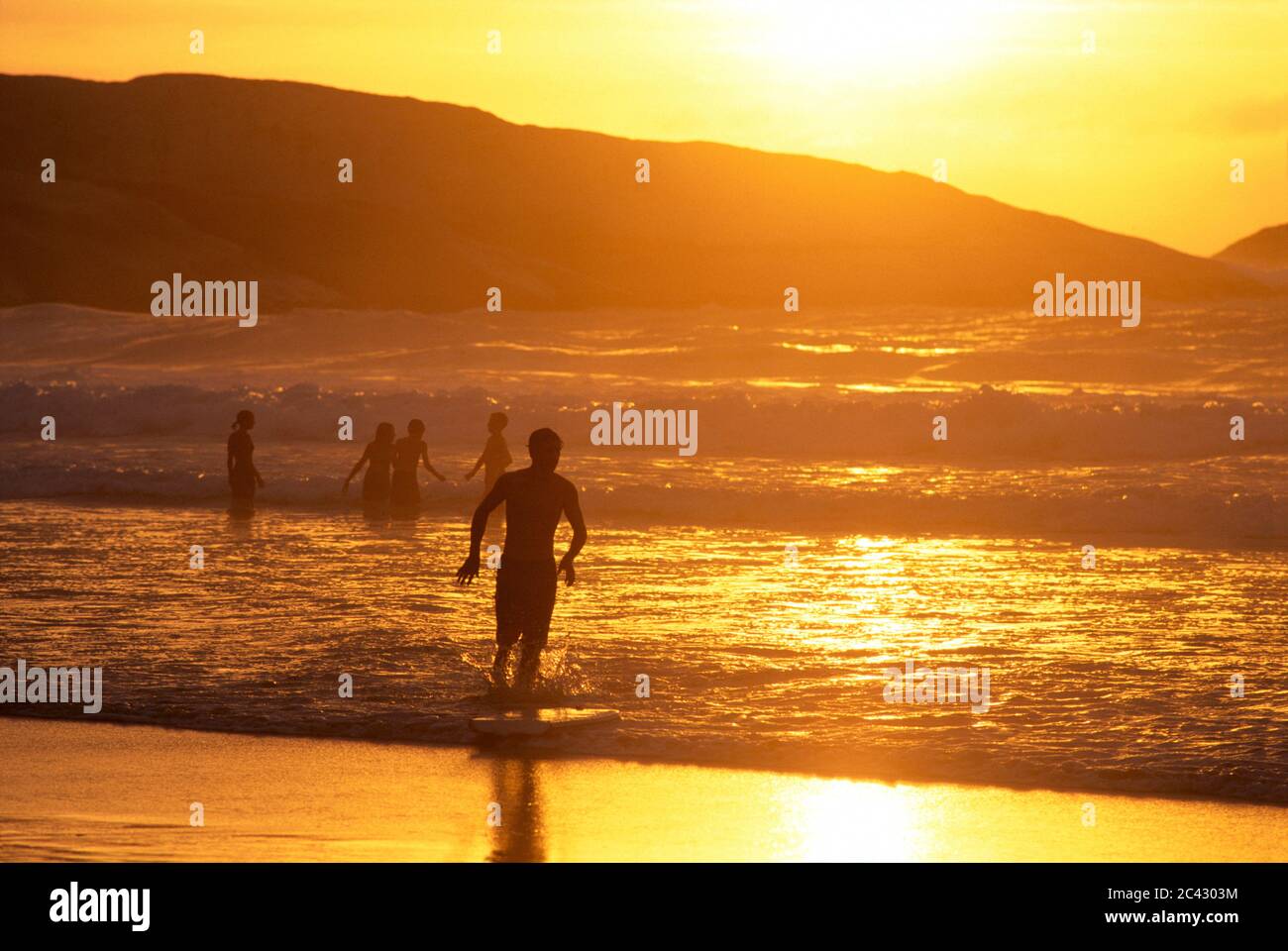 People bathing on the beach - sunset Stock Photo - Alamy