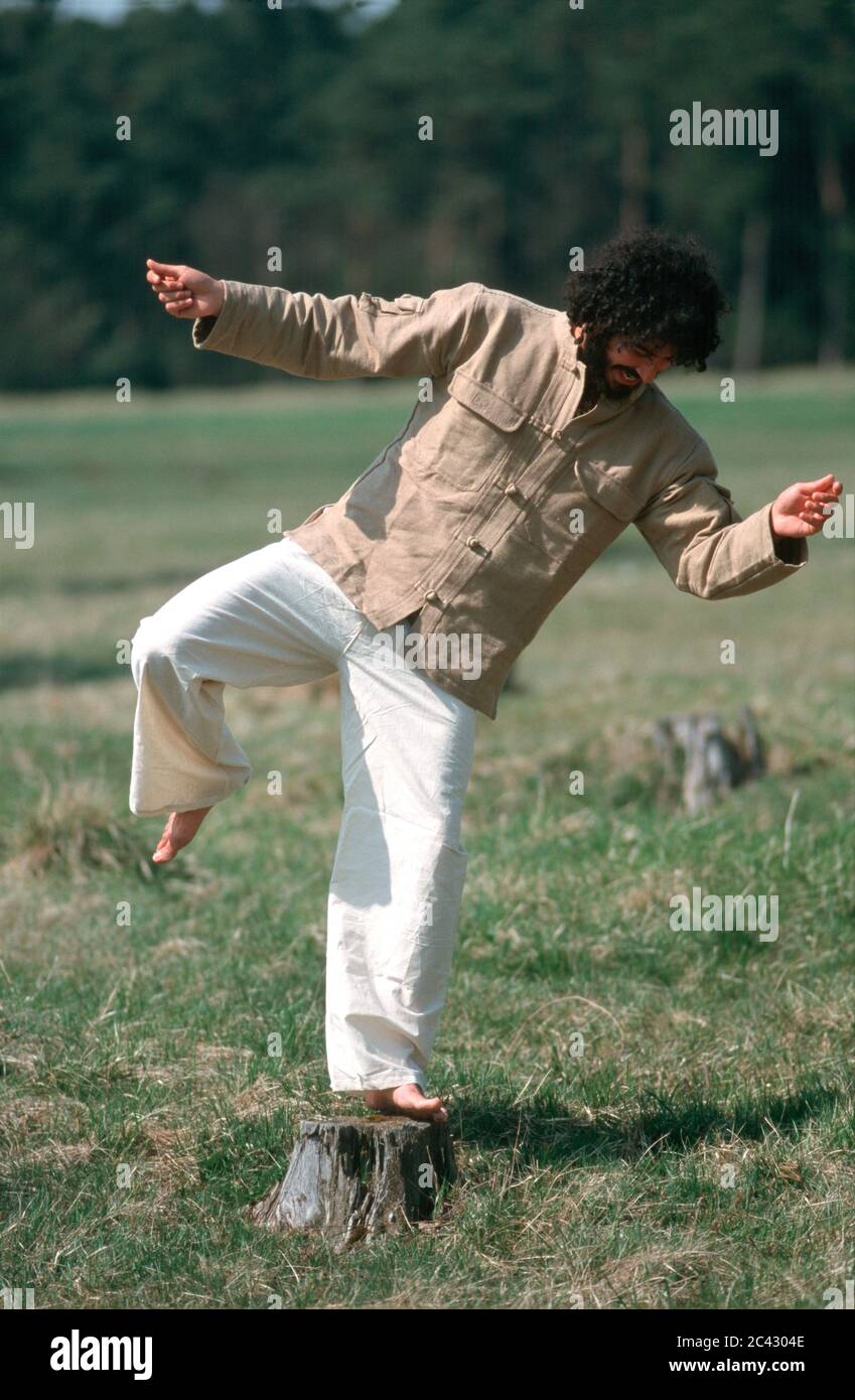 Young man with a beard balances on a stump - balance - nature Stock ...