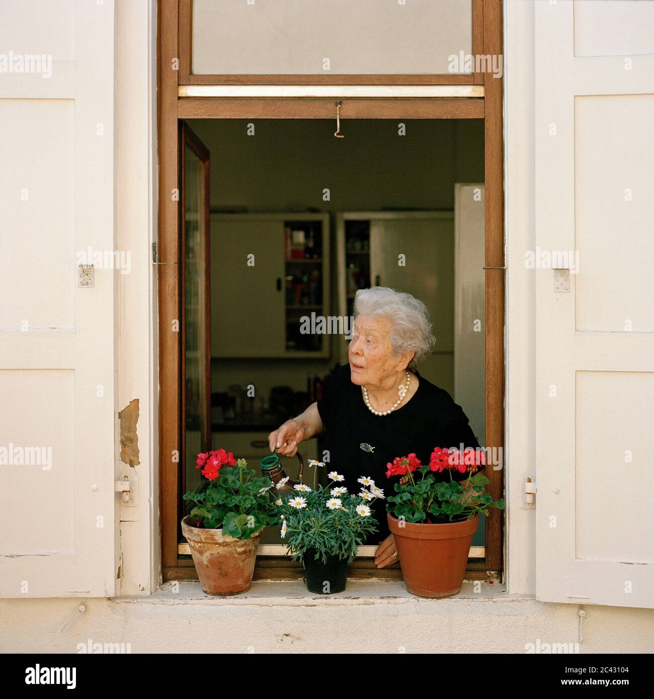 Old woman looks out the window Stock Photo - Alamy