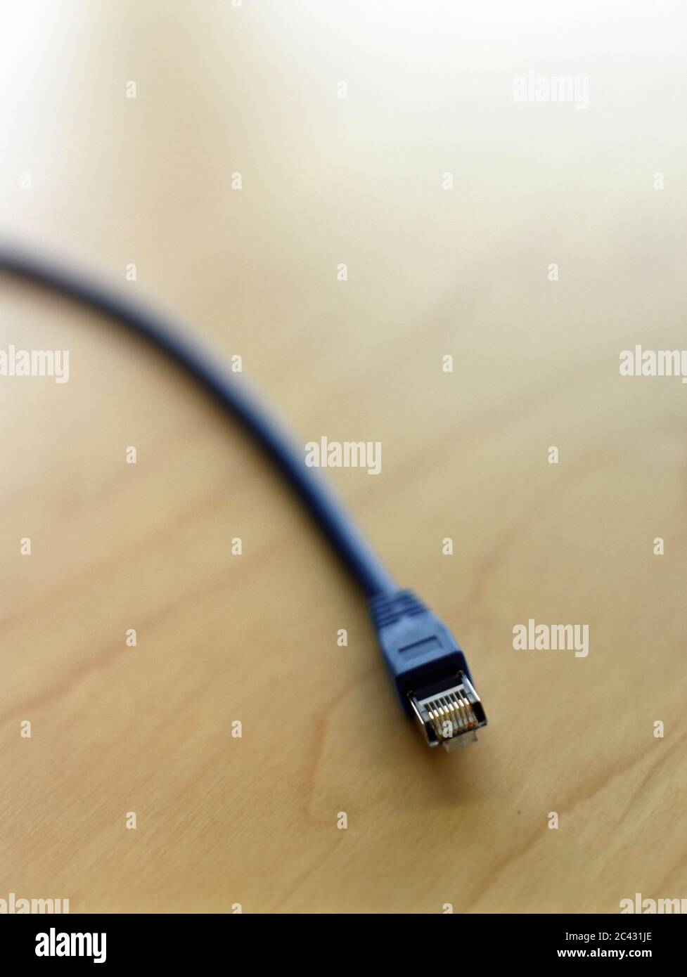A blue computer cable on a beige table - communication Stock Photo - Alamy