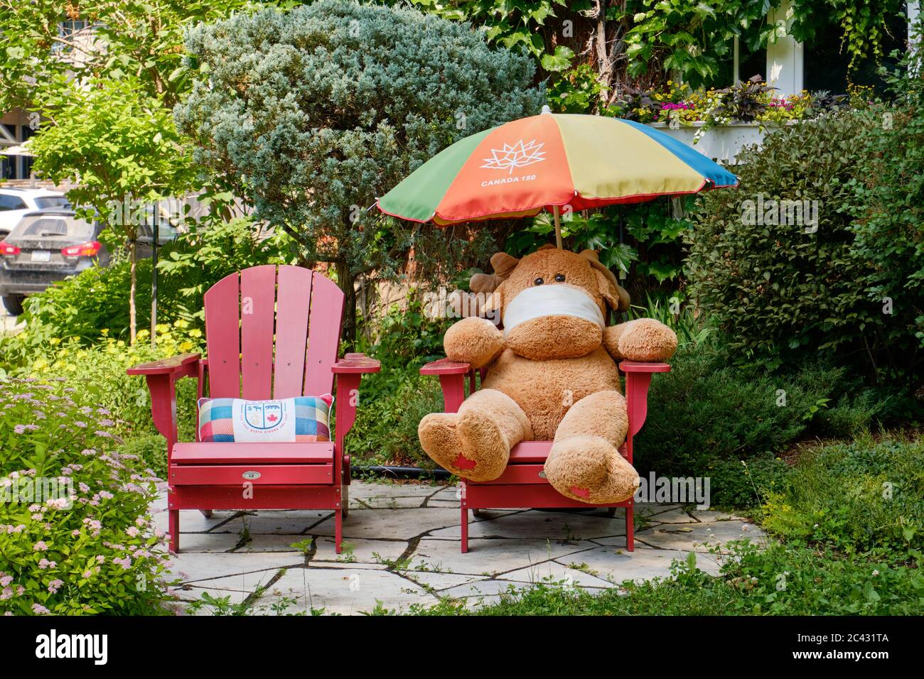Large stuffed Moose with face covering sitting a lawn chair as a ...