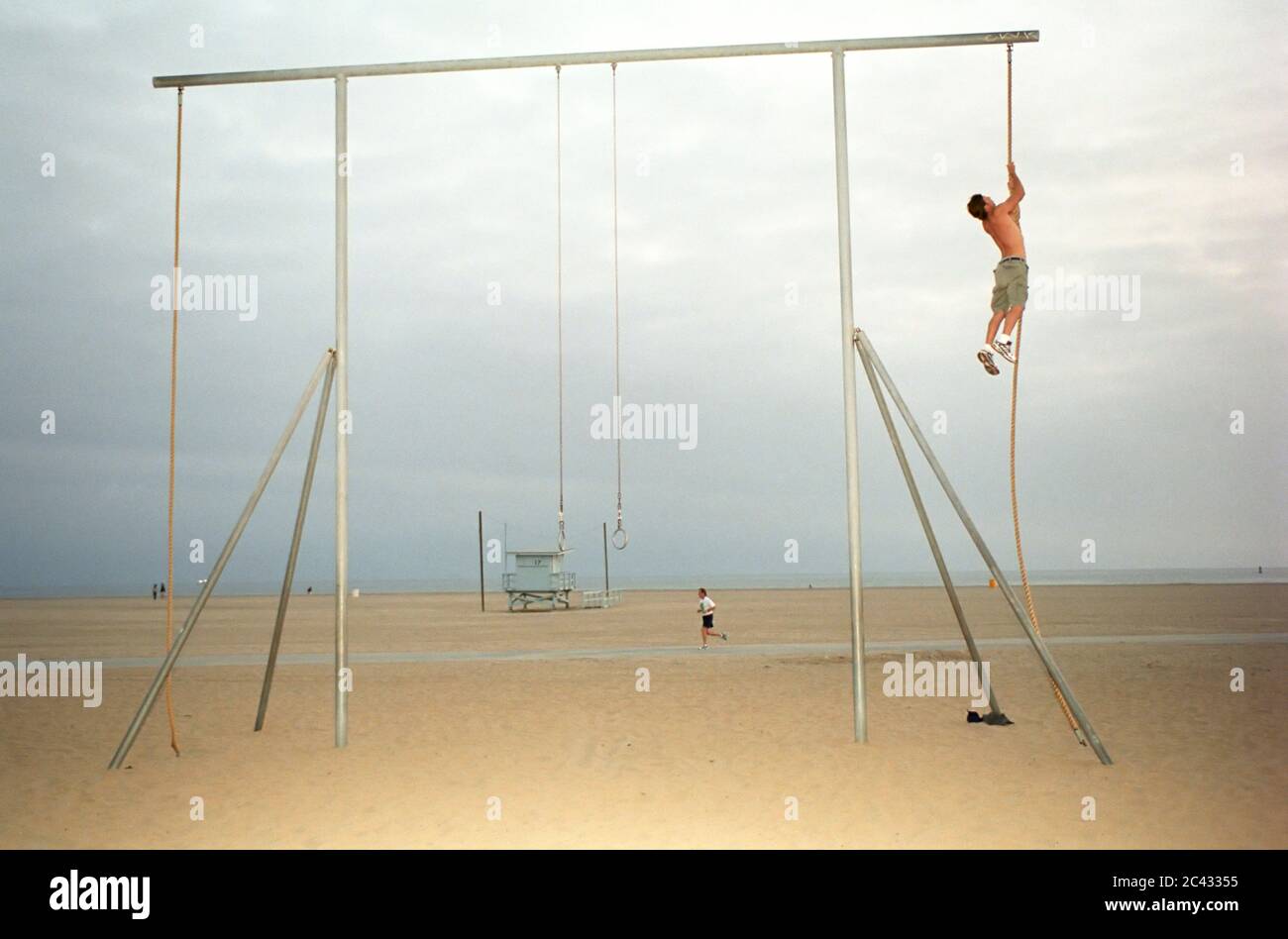 Man climbing up a rope Stock Photo - Alamy