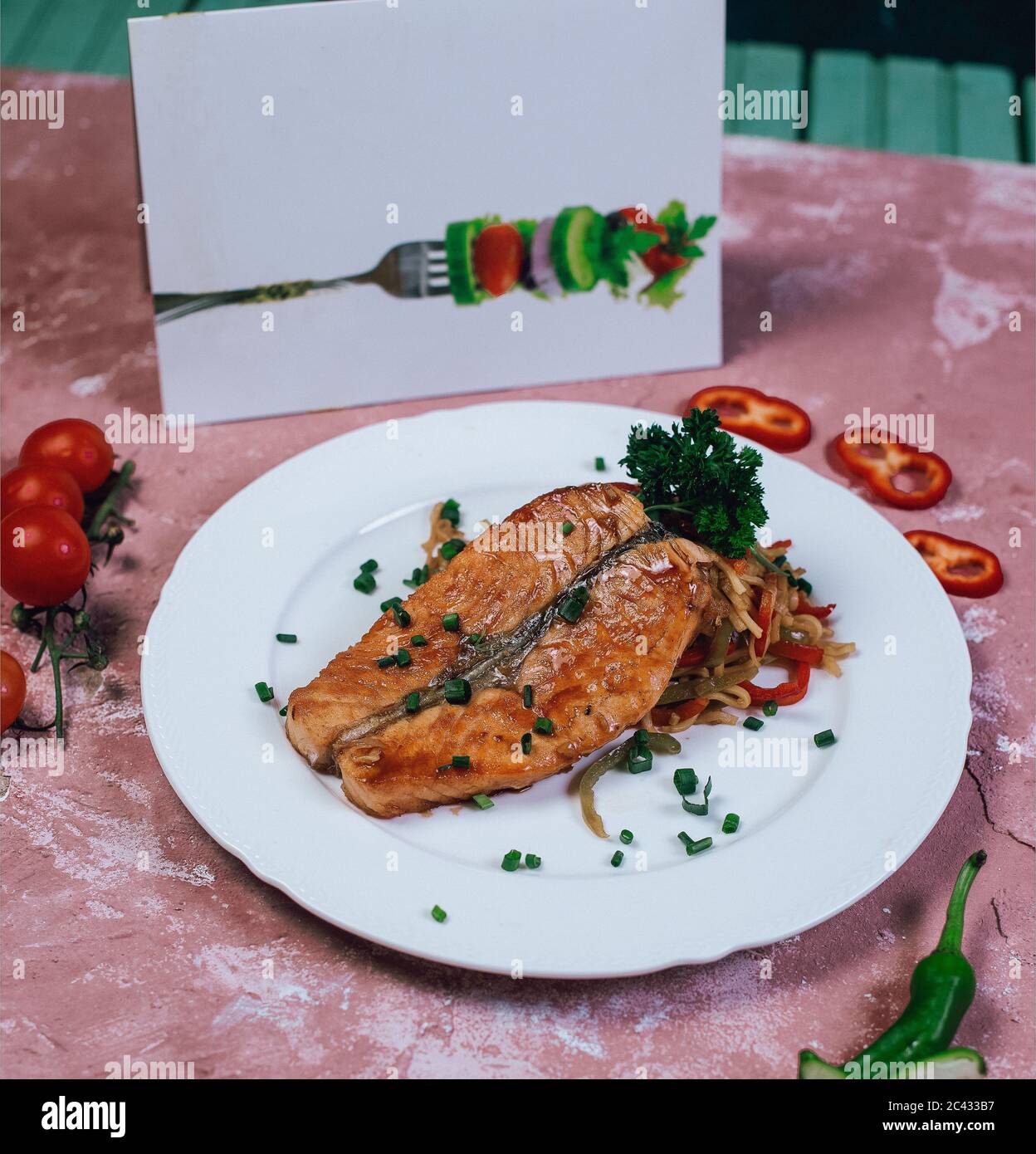 Grilled fish fillet with chopped vegetable salad in white plate Stock ...