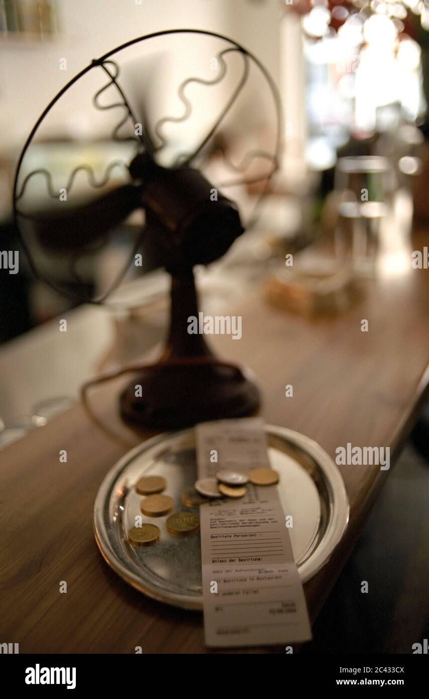 Bill and change on a bar, fan in the background Stock Photo - Alamy