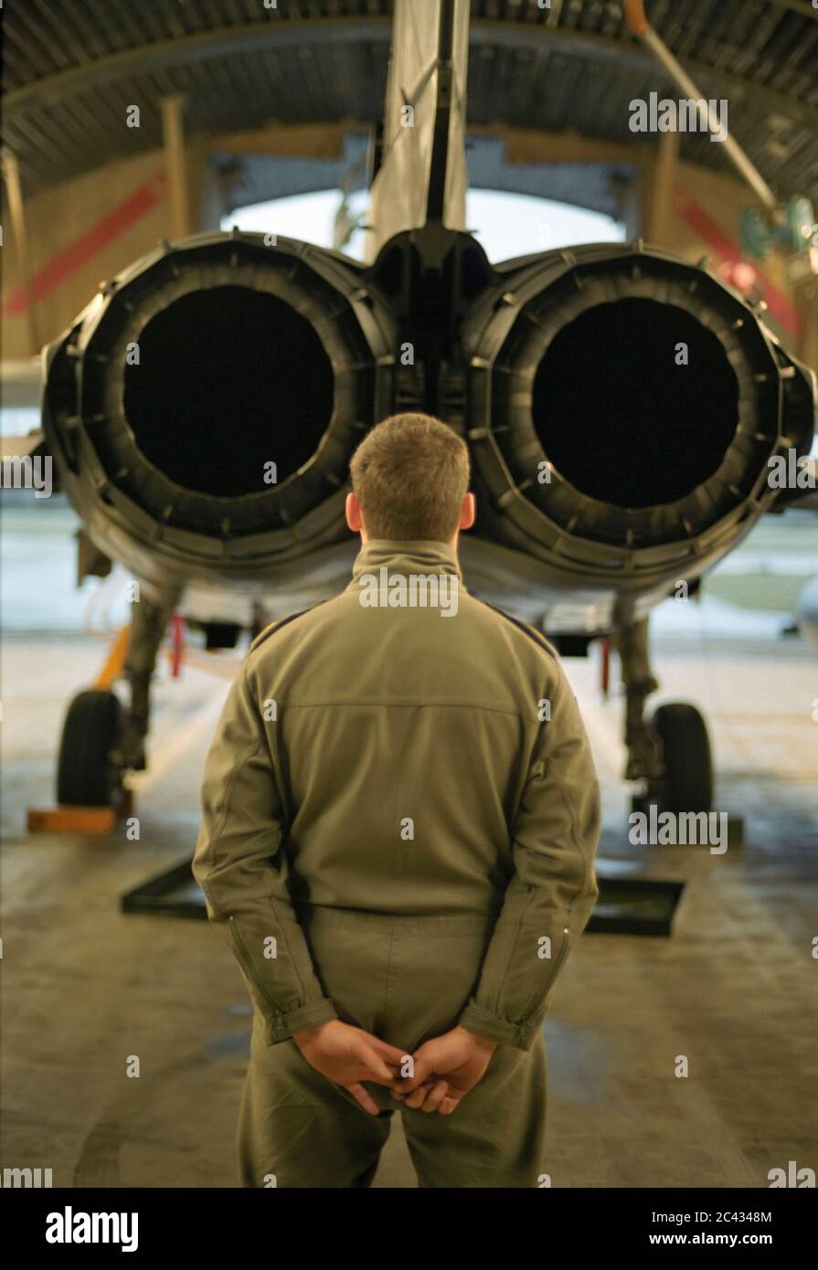 Airman stands behind a jet plane Stock Photo - Alamy