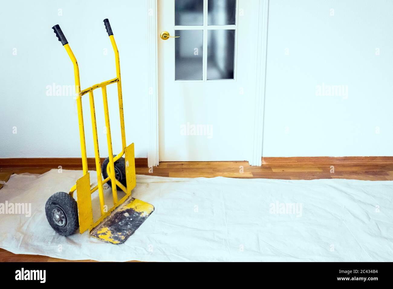 Manual yellow wheelbarrow in a room Stock Photo - Alamy