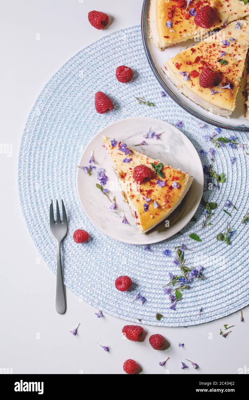 Sliced homemade raspberry baked cheesecake on plate decorated by fresh ...