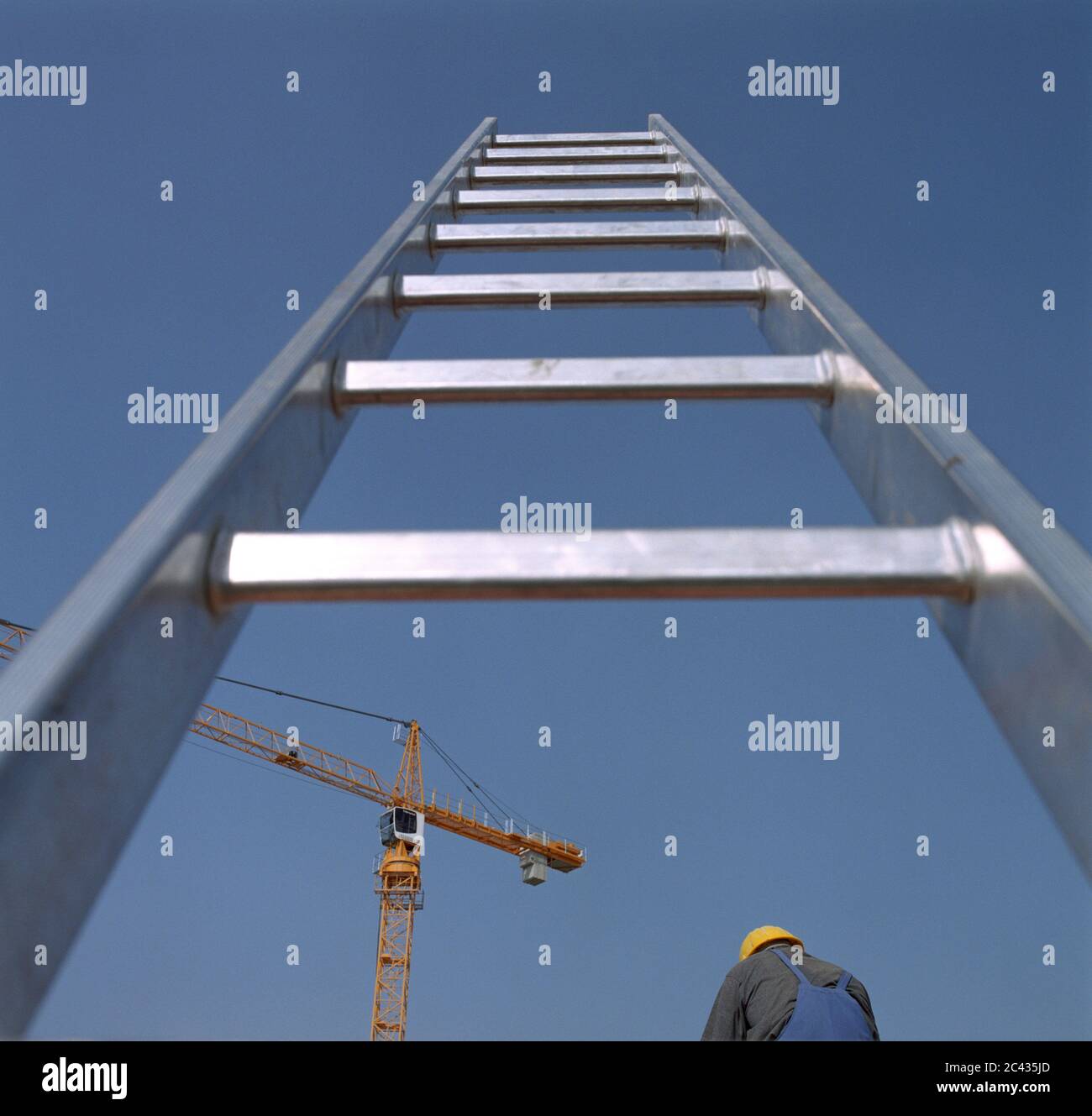 Construction worker behind a ladder under a crane - construction site ...
