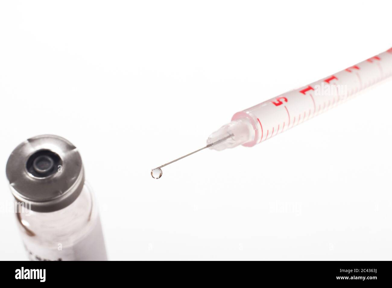 Syringe next to a vial of serum Stock Photo - Alamy