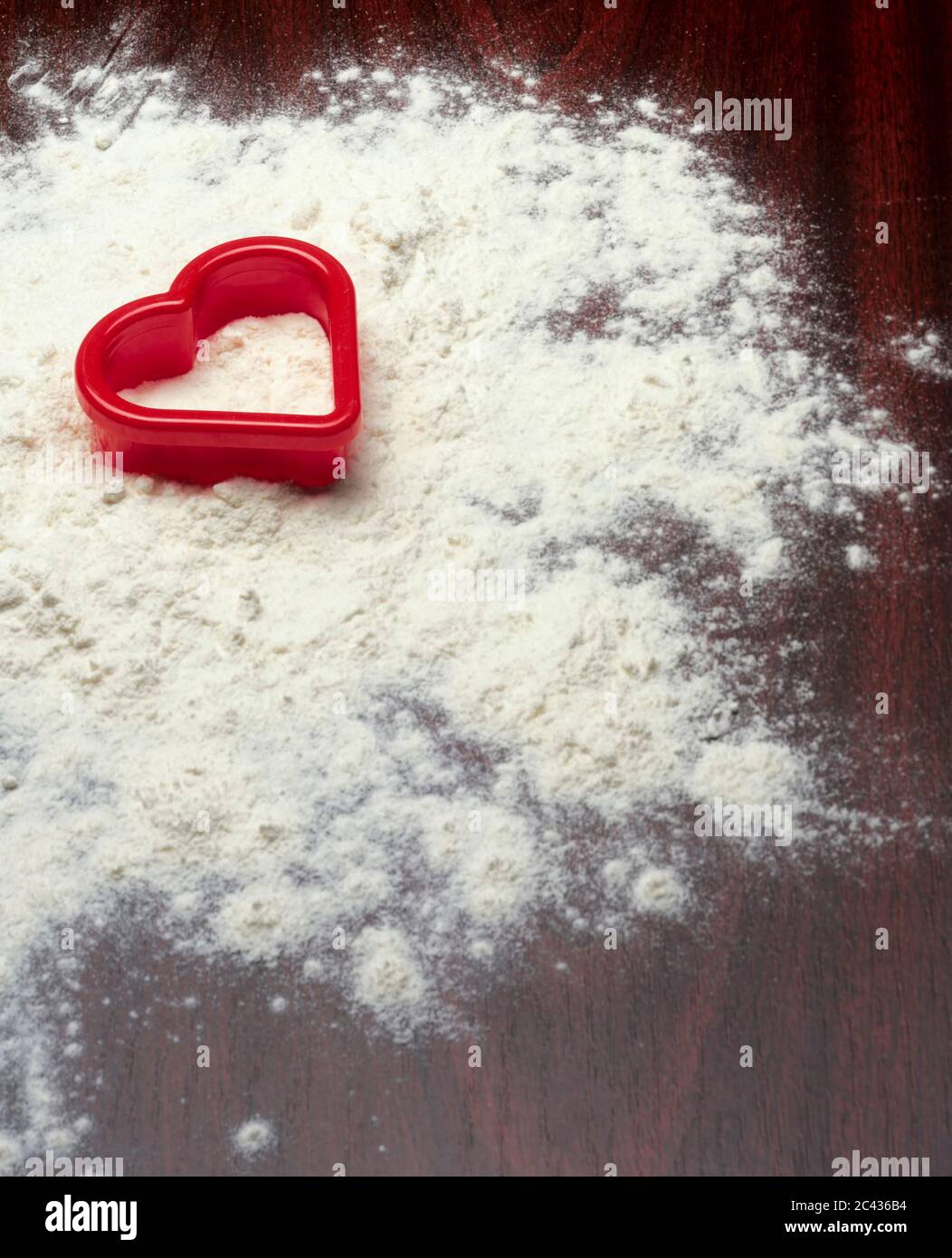 Heart-shaped cookie cutter in the flour Stock Photo - Alamy
