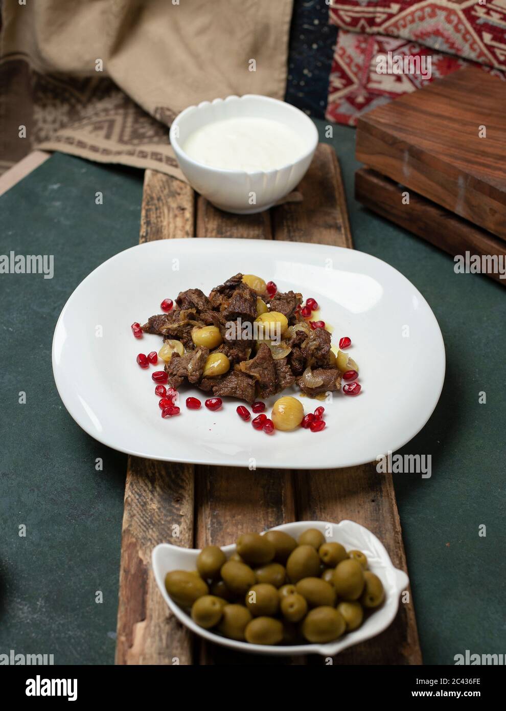 Meat sauteed with chestnuts and pomegranate seeds Stock Photo - Alamy