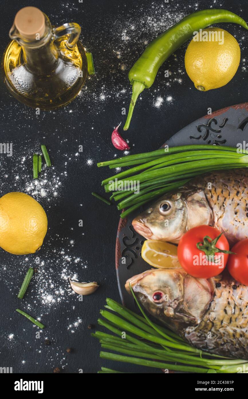 Raw fish heads with greenery, lemon and tomatoes, top view Stock Photo ...