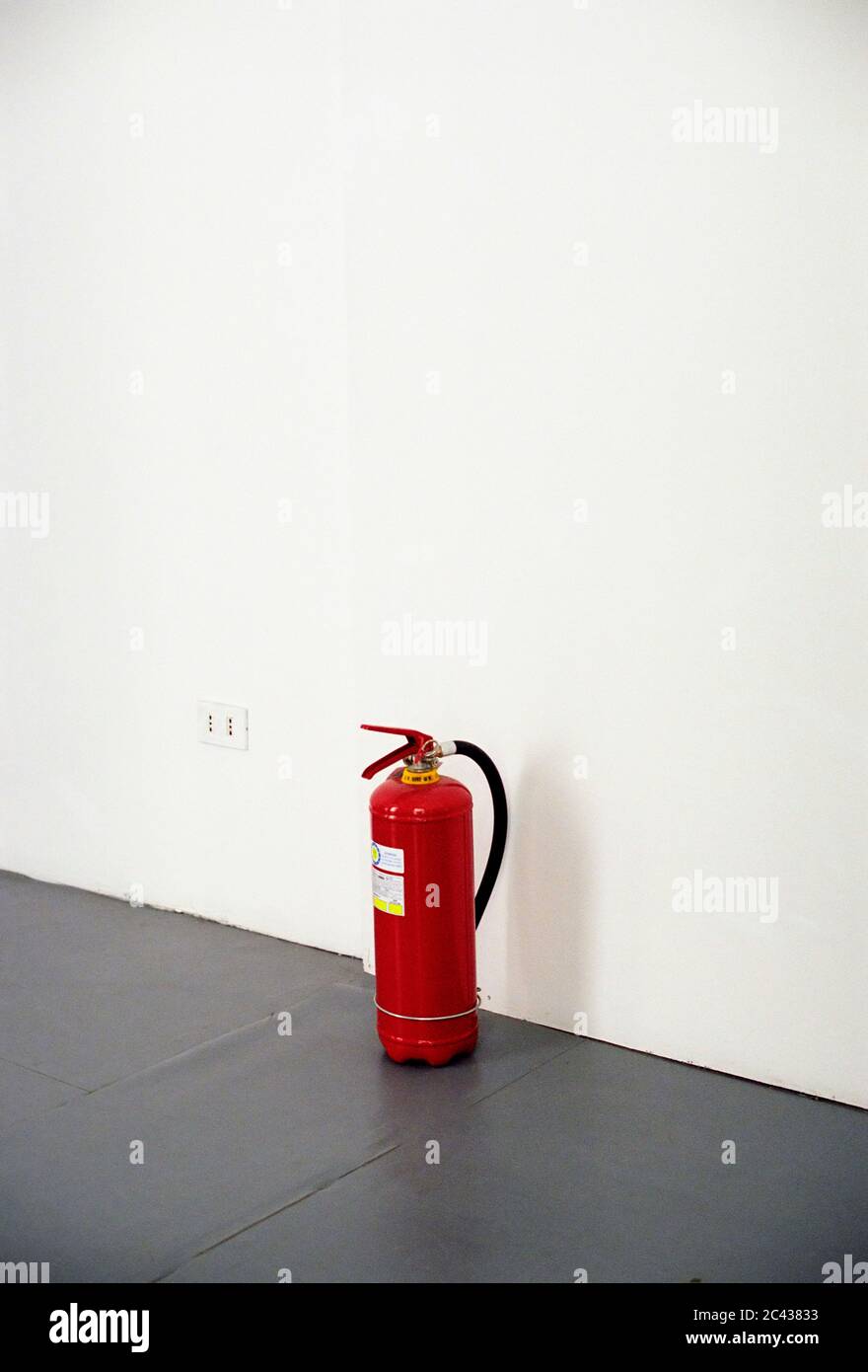A fire extinguisher stands on the floor - danger - space Stock Photo ...