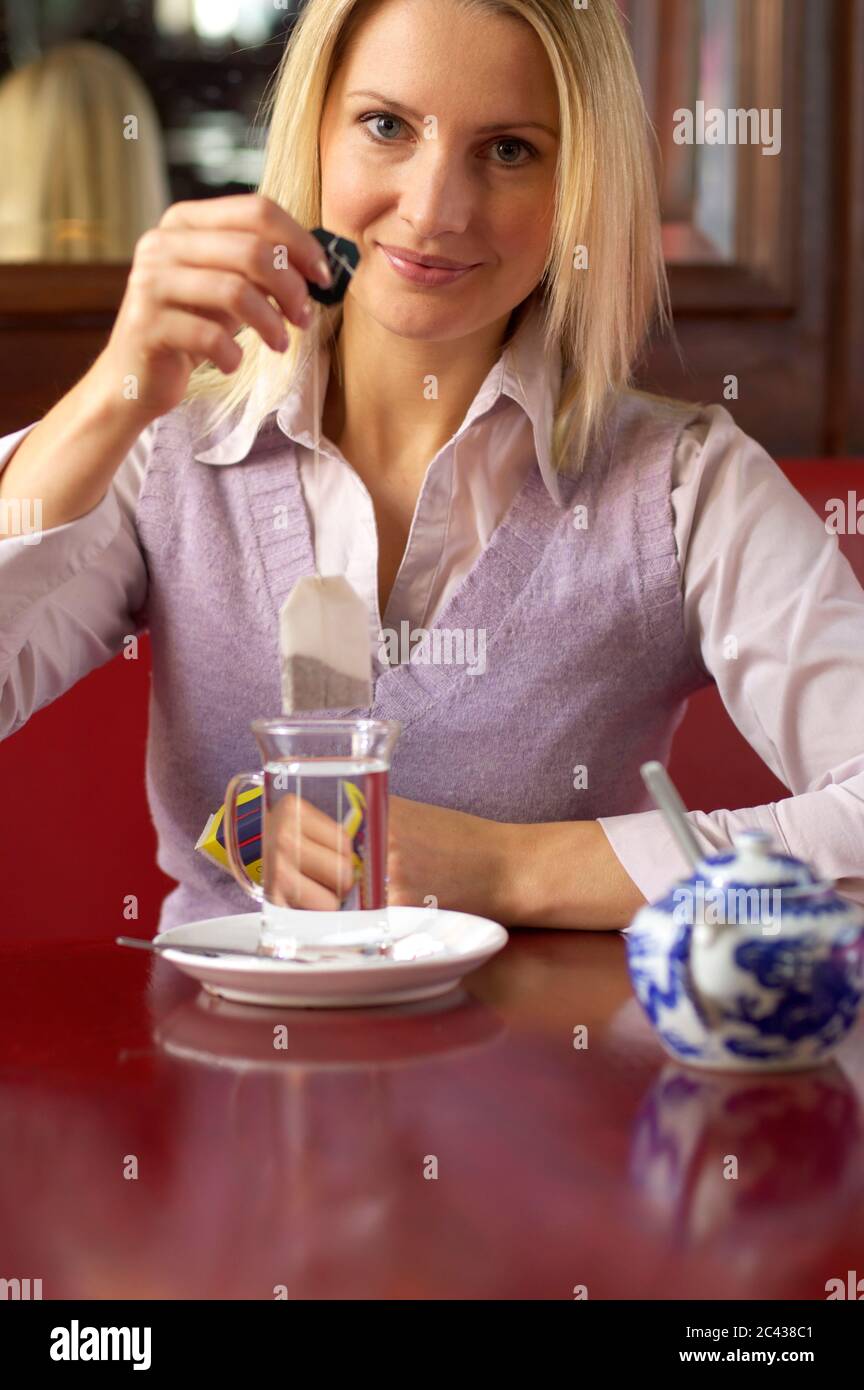 Woman puts a tea bag in a glass of water Stock Photo - Alamy