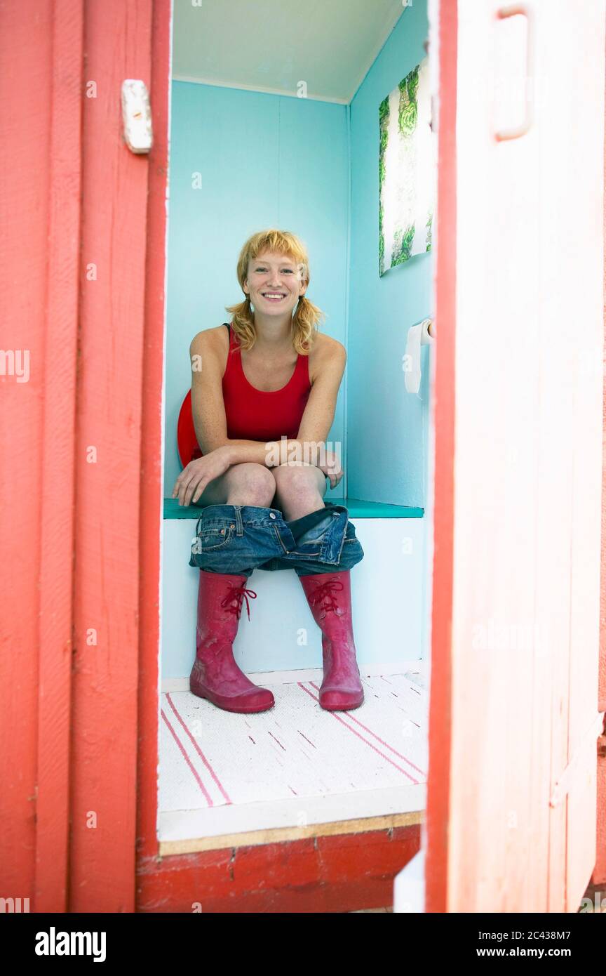 Woman is sitting on a latrine Stock Photo - Alamy