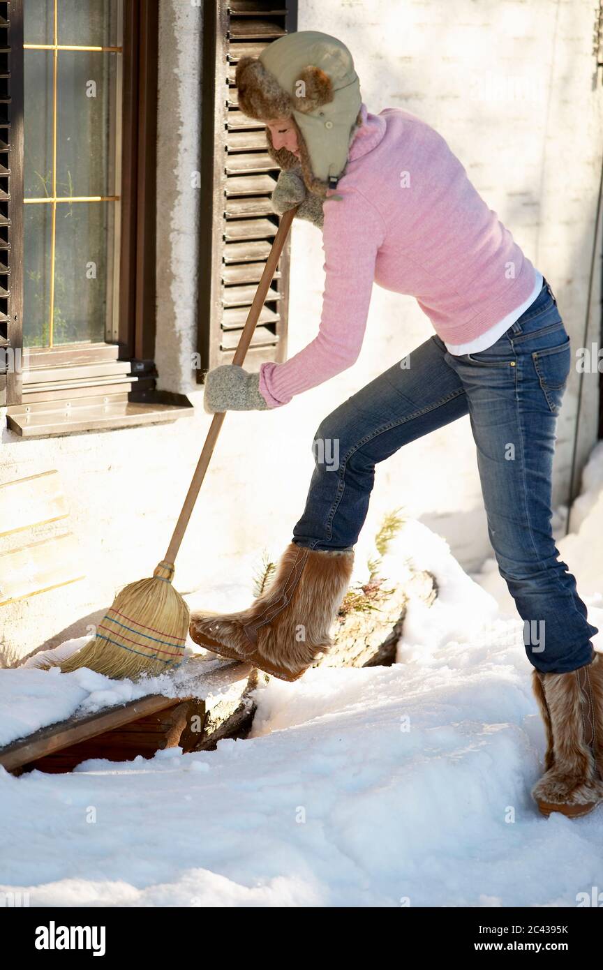 Woman is sweeping snow away Stock Photo - Alamy