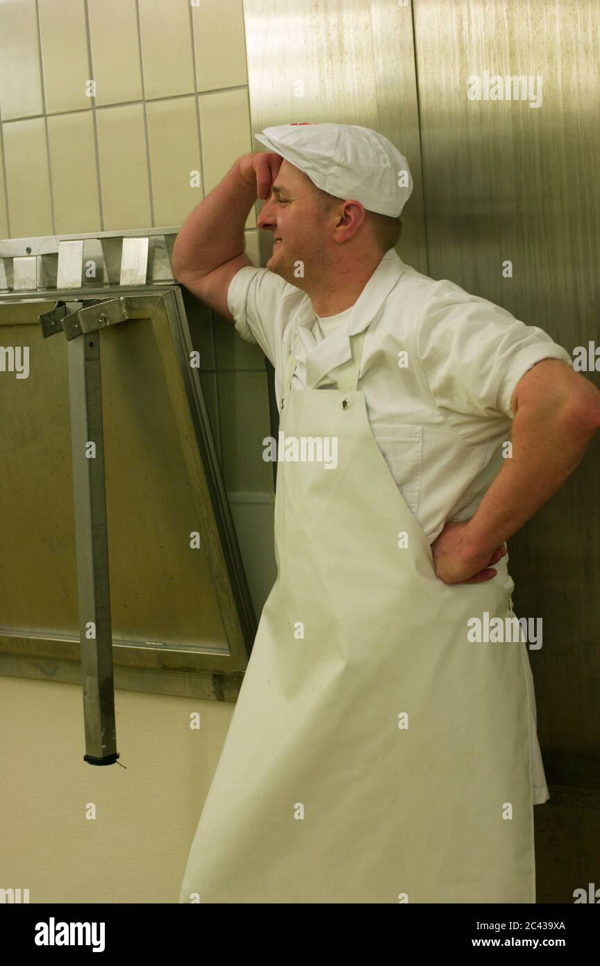 Laughing butcher leans against a wall Stock Photo - Alamy