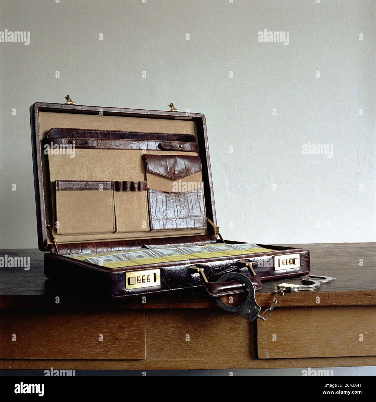 Money case with handcuffs Stock Photo - Alamy