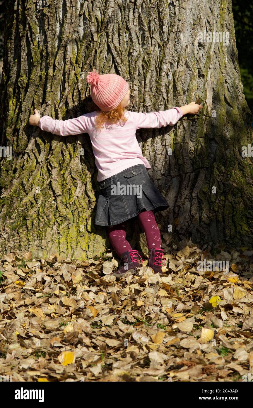 Girl hugging a tree Stock Photo - Alamy