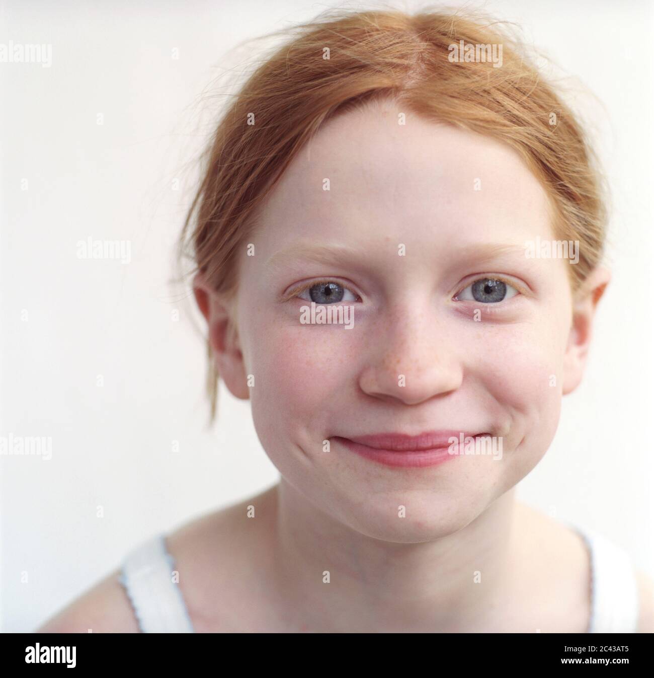 Girl with red hair smiles cheekily - physicality Stock Photo - Alamy
