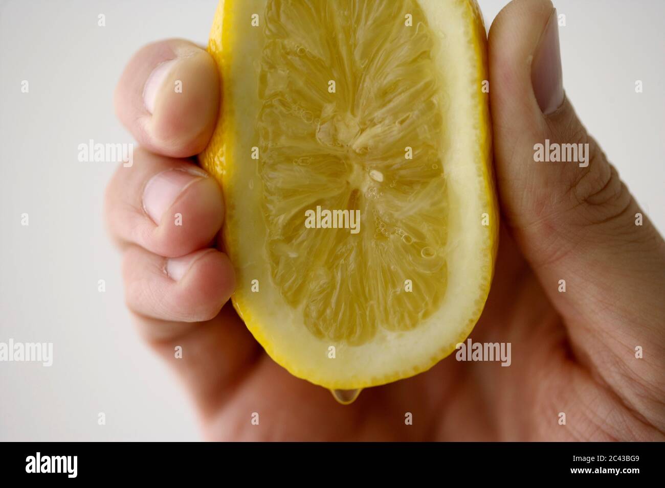 Man squeezes a lemon Stock Photo - Alamy