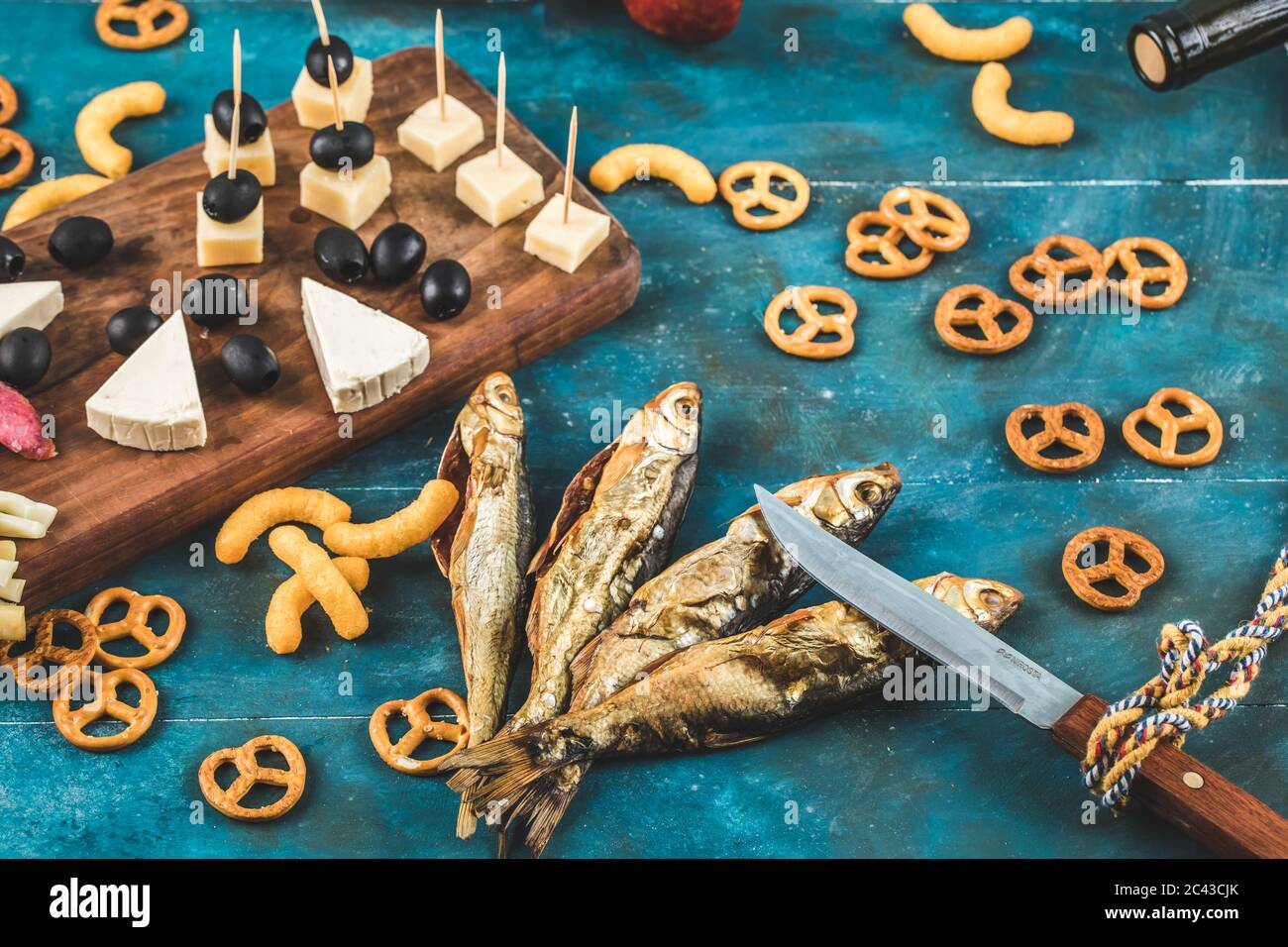 Dry fish and crackers on the blue table with cheese and olives Stock ...