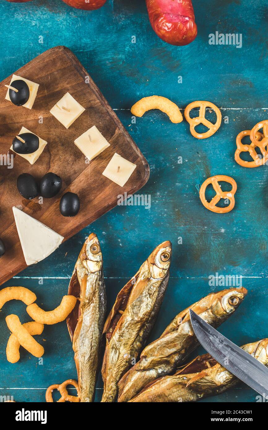 Dried fish snacks on the blue background with pretzel crackers, top ...