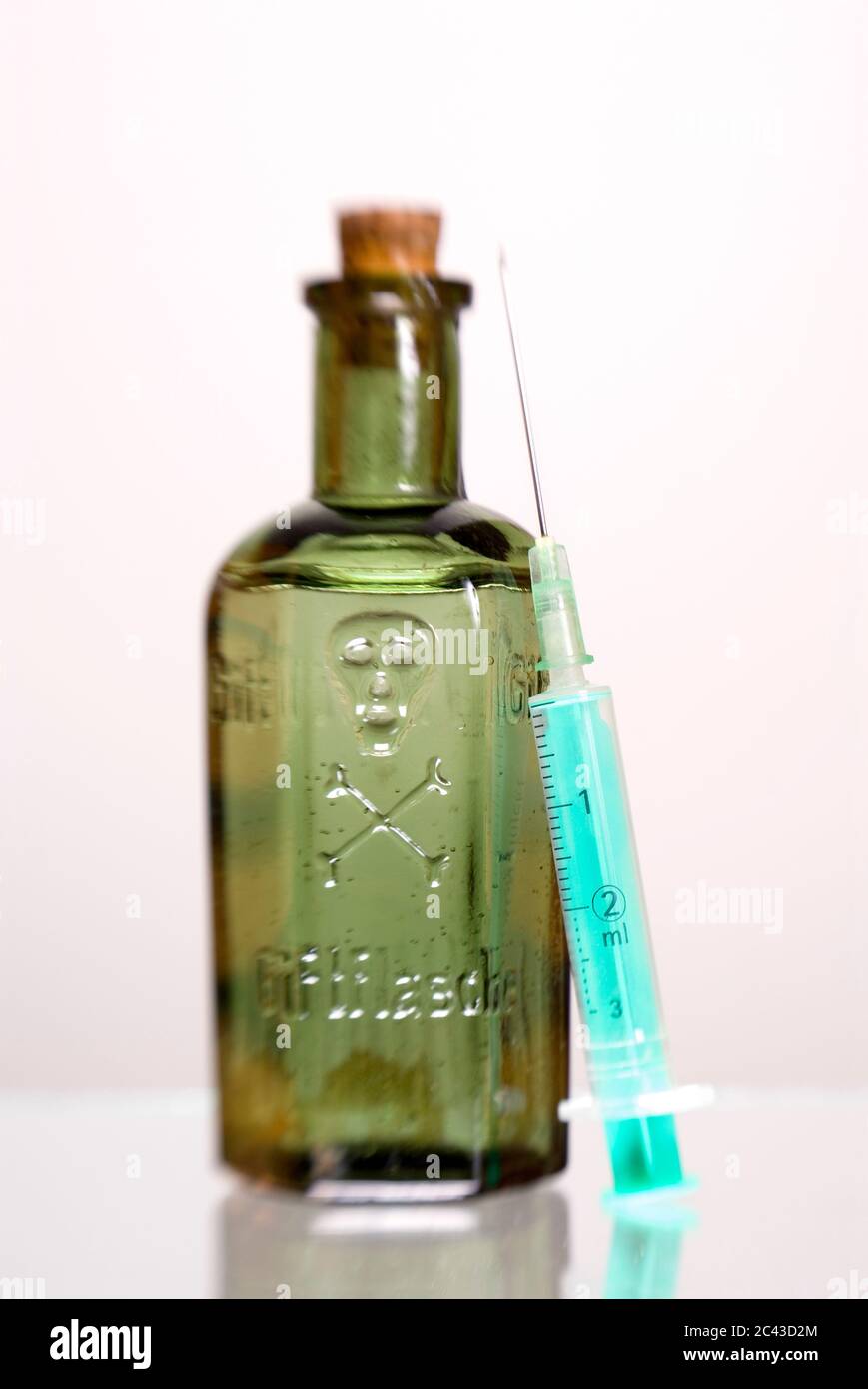 Syringe leans against a poison bottle Stock Photo - Alamy