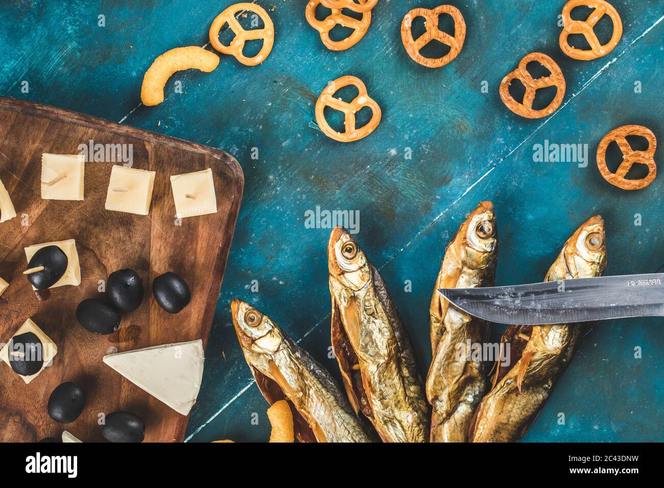 Dry fish snack with cheese, olive and crackers on the blue table Stock ...