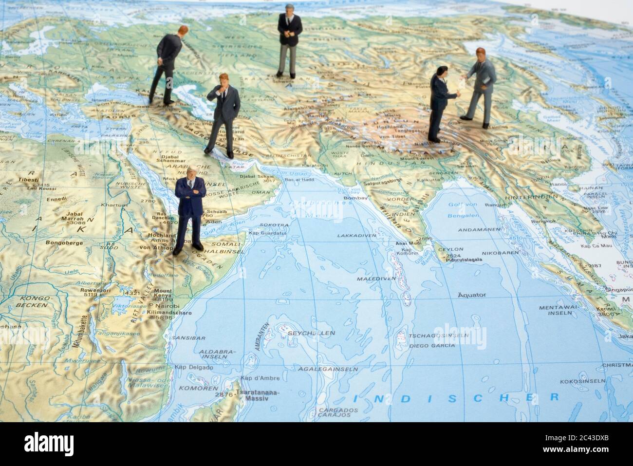 Businessman figures stand on a world map Stock Photo - Alamy