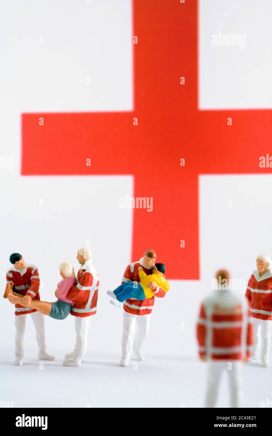 Medic figures in front of a red cross Stock Photo - Alamy