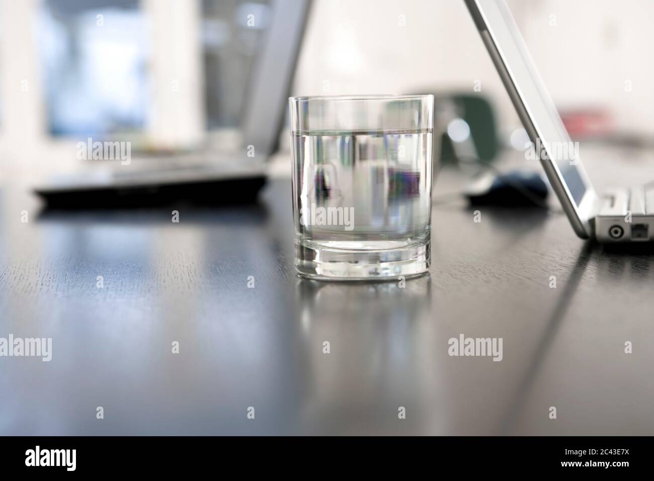 Water glass on a desk - office work Stock Photo - Alamy