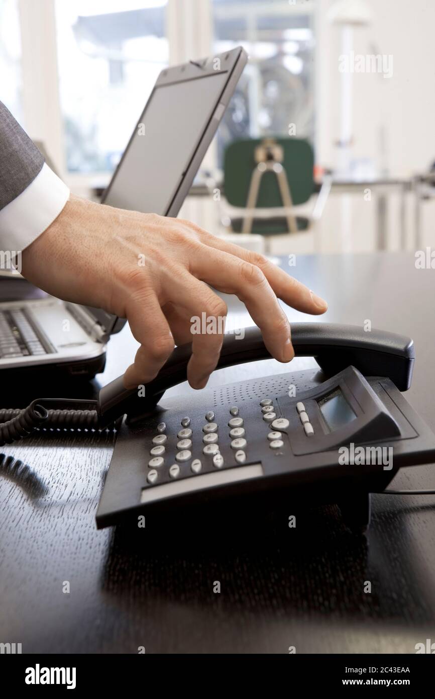 Hand hangs up a handset - call - phone Stock Photo - Alamy