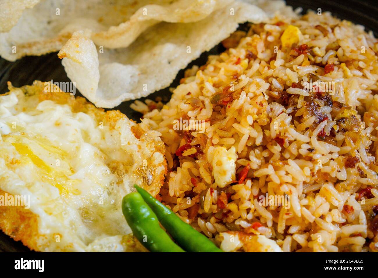 Spicy fried rice with dried chilli with fried egg and fish cracker ...